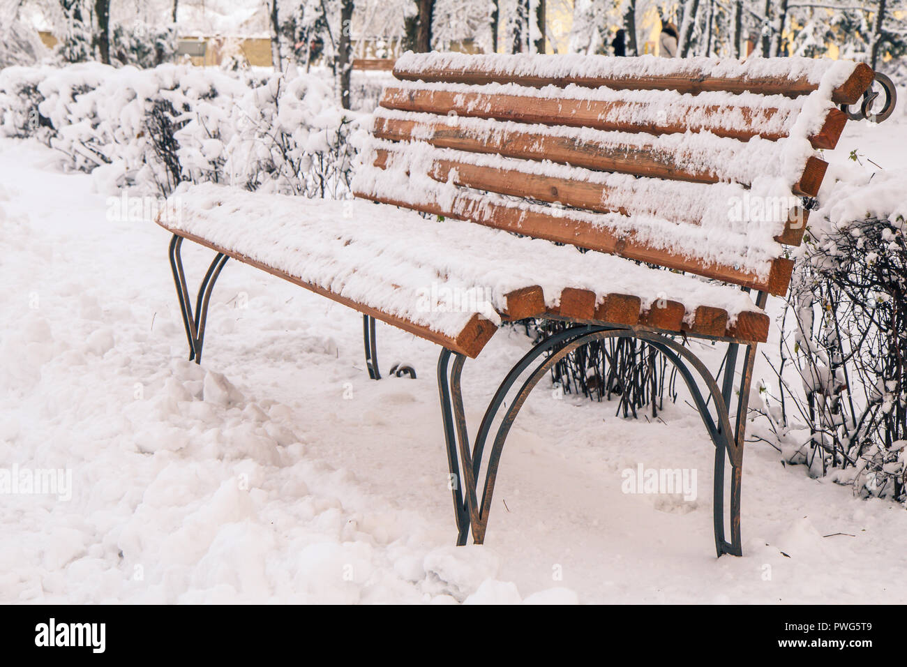 Bench covered with snow in snowbound city in winter. Winter time Stock ...