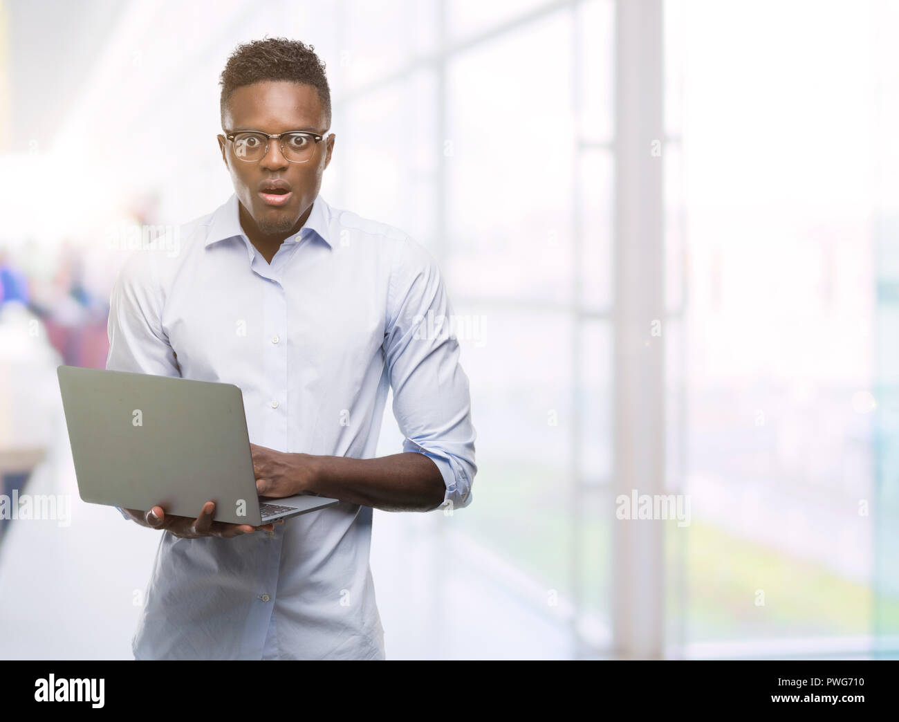 Young african american businessman using computer laptop scared in ...