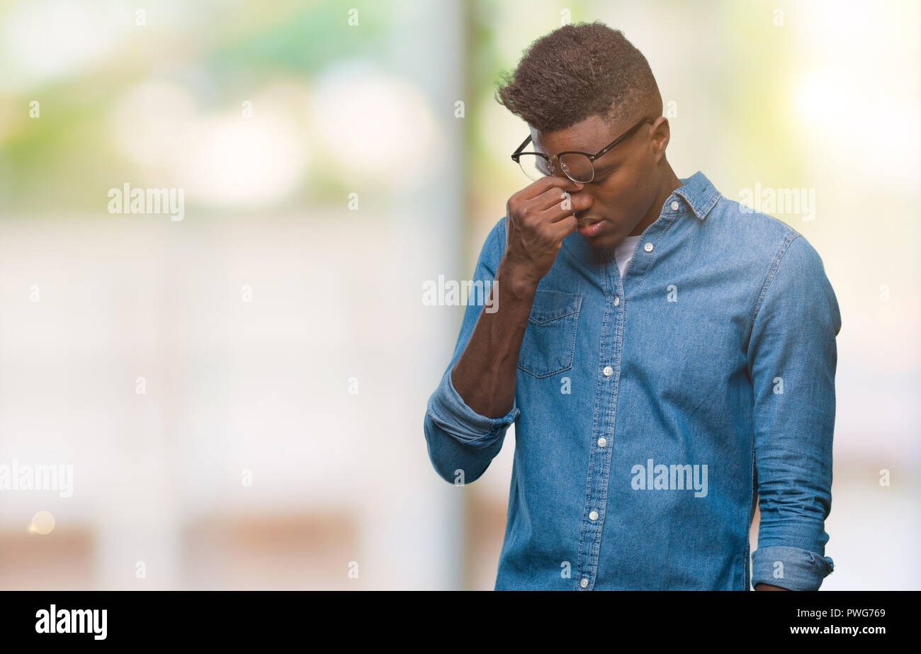 Young african american man over isolated background tired rubbing nose ...