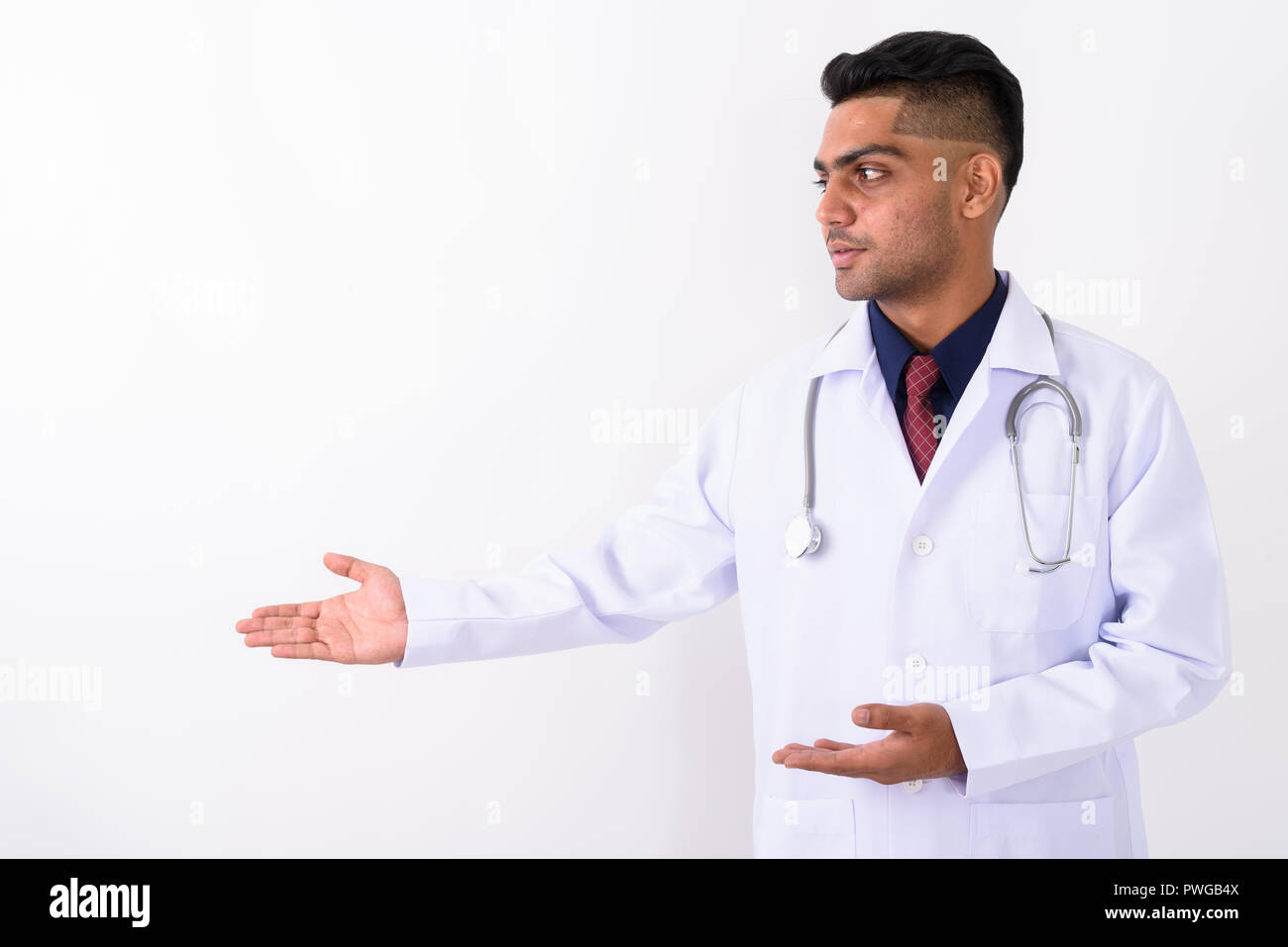 Young Indian man doctor against white background Stock Photo - Alamy