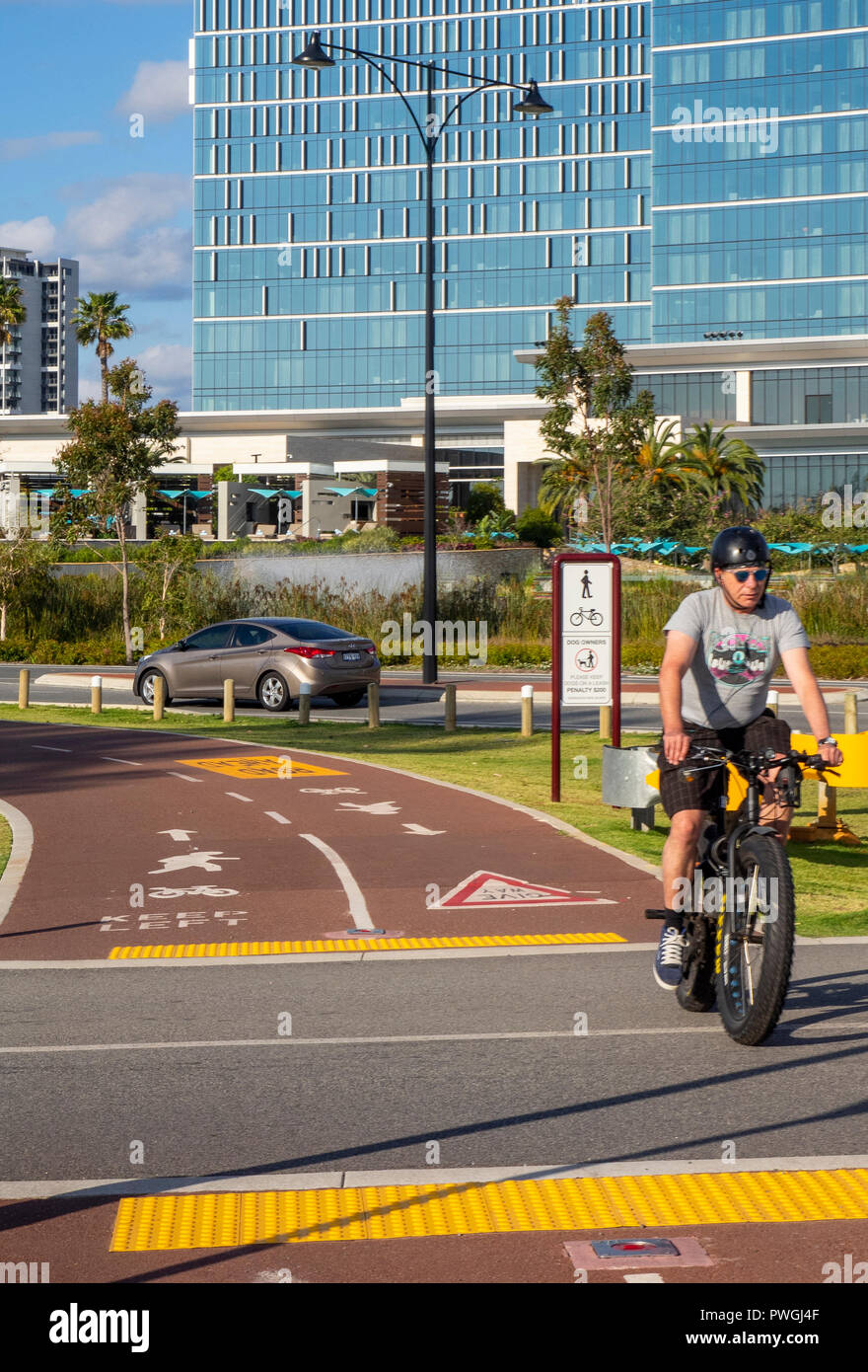 Cyclist riding fat bike bicycle cycling past Crown Towers luxury hotel ...