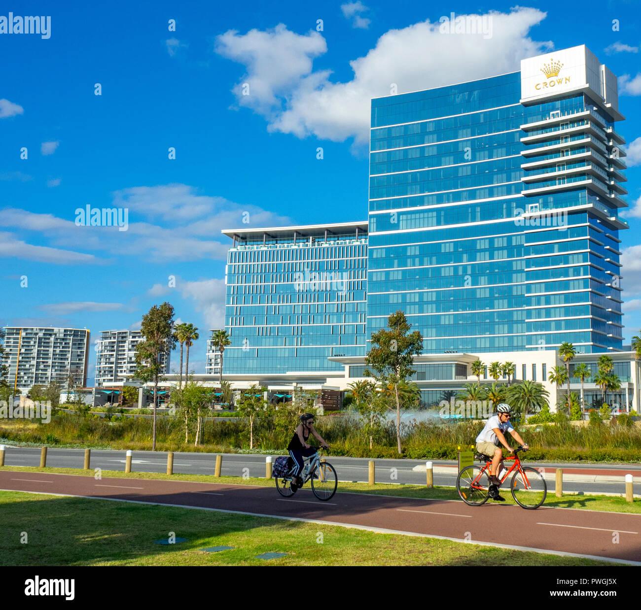 Cyclists riding bicycles cycling past Crown Towers luxury hotel in ...