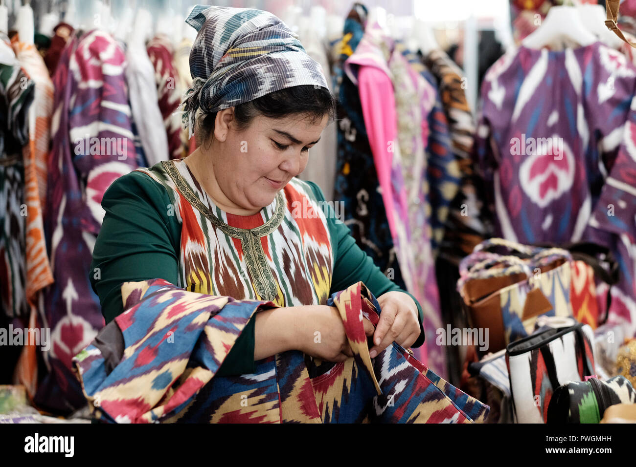 An Uzbek stall holder selling traditional garment in the city of ...