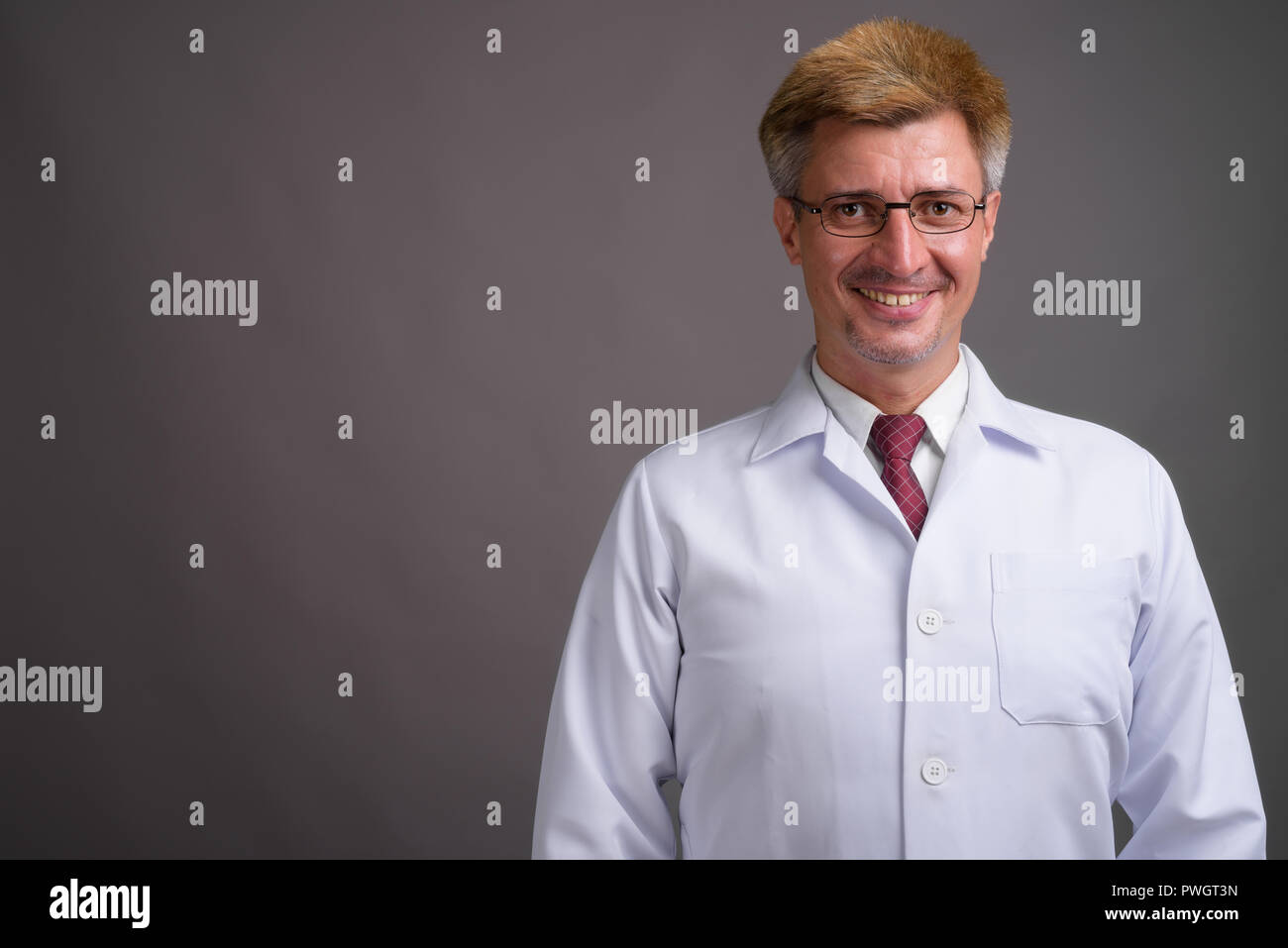 Man doctor with blond hair against gray background Stock Photo - Alamy