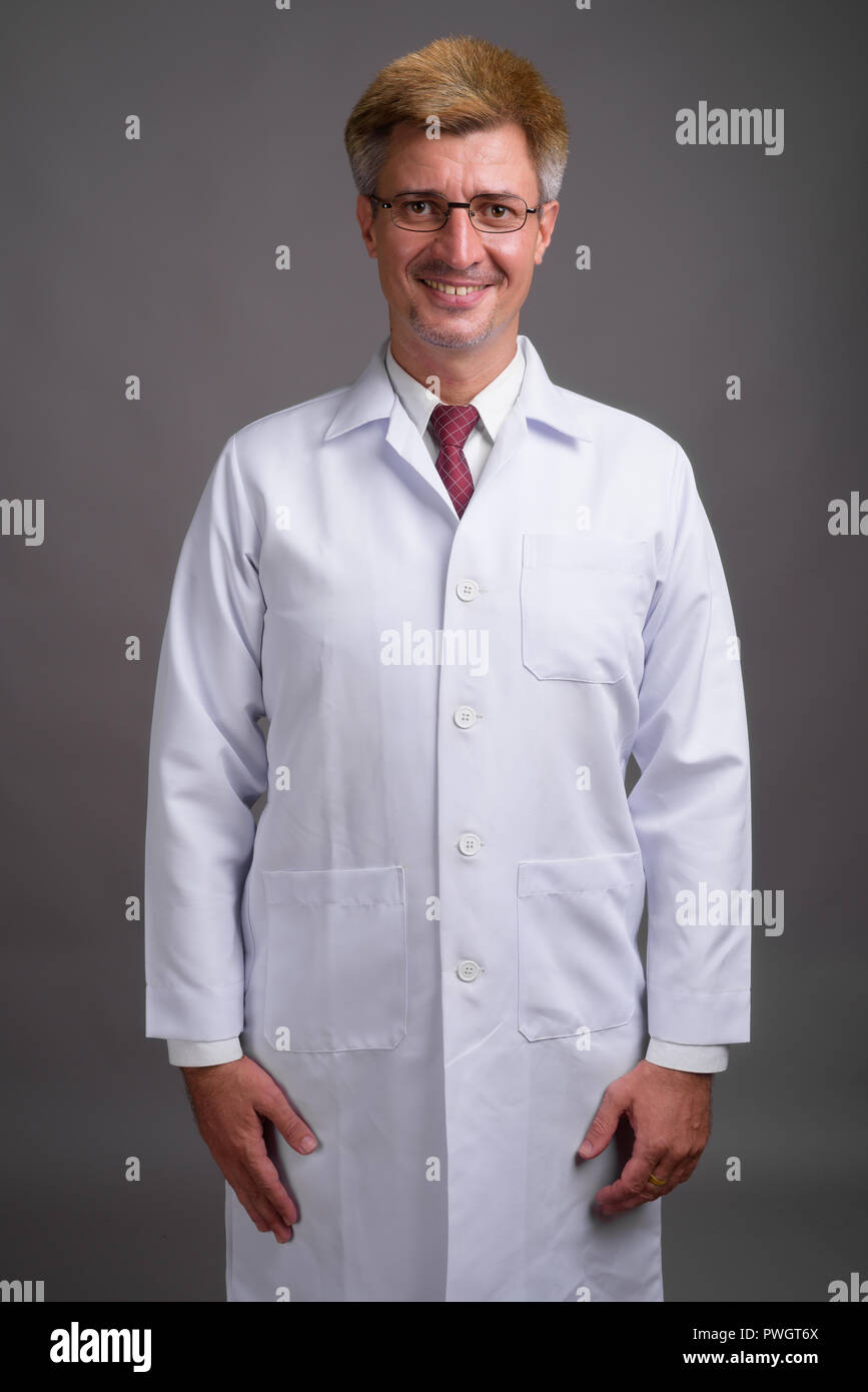Man doctor with blond hair against gray background Stock Photo - Alamy