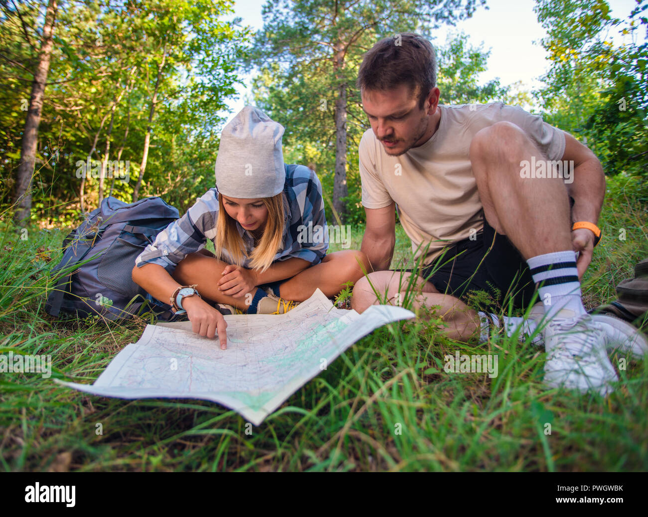 Young couple navigasting using map and compass inside the forest ...