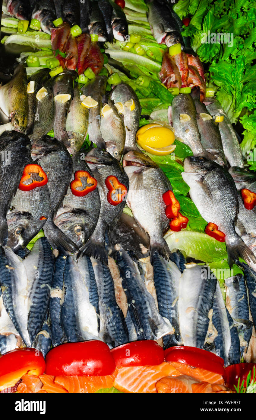 Various types of fish with red bell pepper,lemon, letucce in the market ...