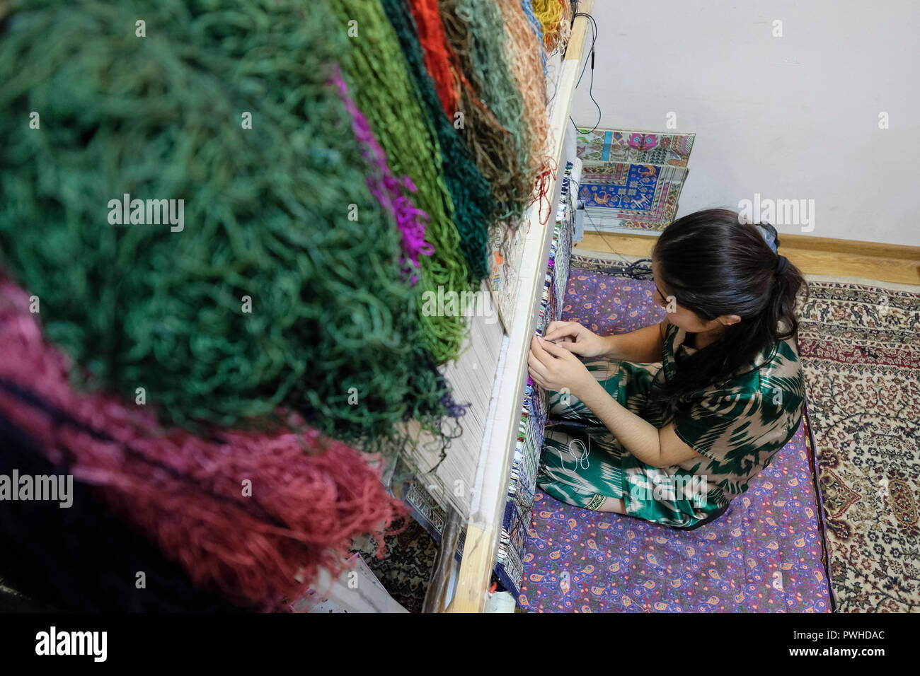 Hand loom weaver at a silk carpet workshop in the city of Bukhara ...