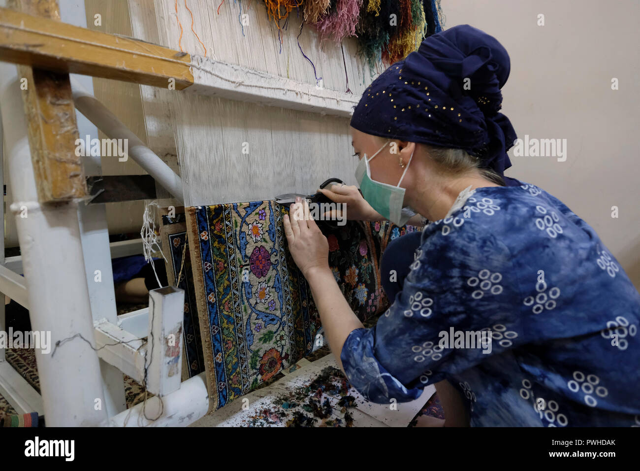 Hand loom weaver at a silk carpet workshop in the city of Bukhara ...