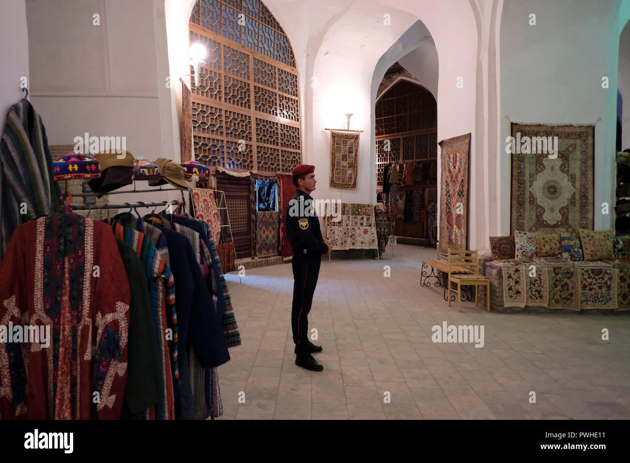 An Uzbek security man stands guard in a vaulted stone structure in ...