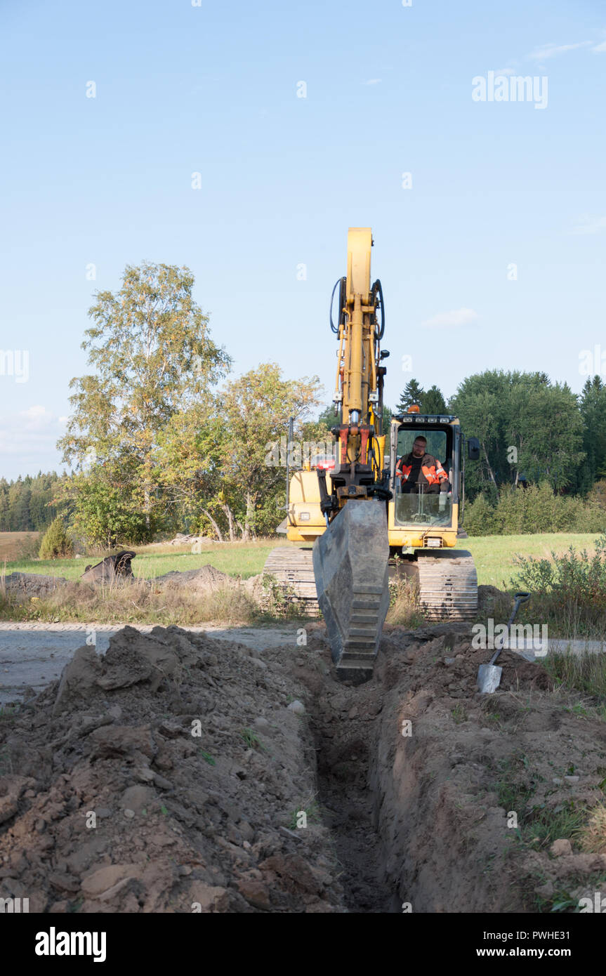 Digger laying underground electric cables Stock Photo - Alamy