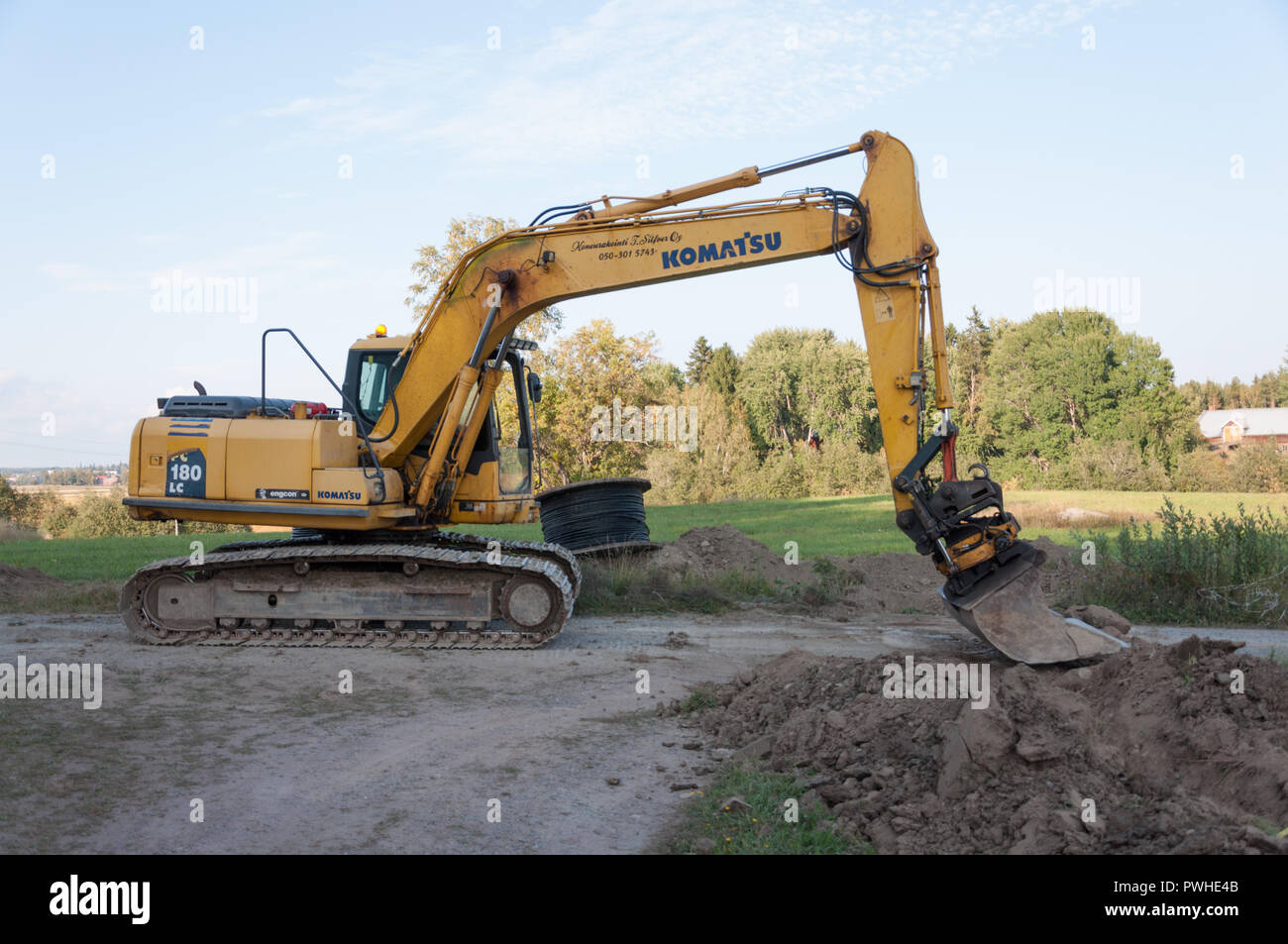 Digger laying underground electric cables Stock Photo - Alamy