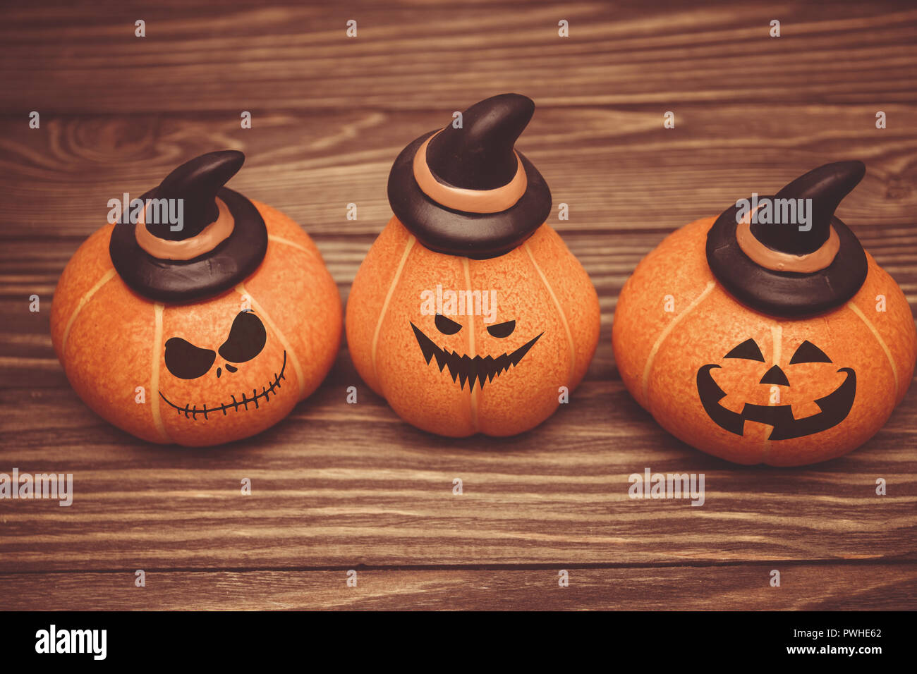 three laughing pumpkin faces frightening for Halloween on a wooden ...