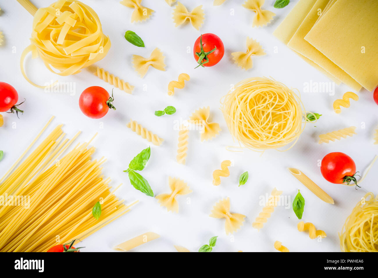 Italian food concept, various raw pasta assortment - spaghetti, lasagna ...