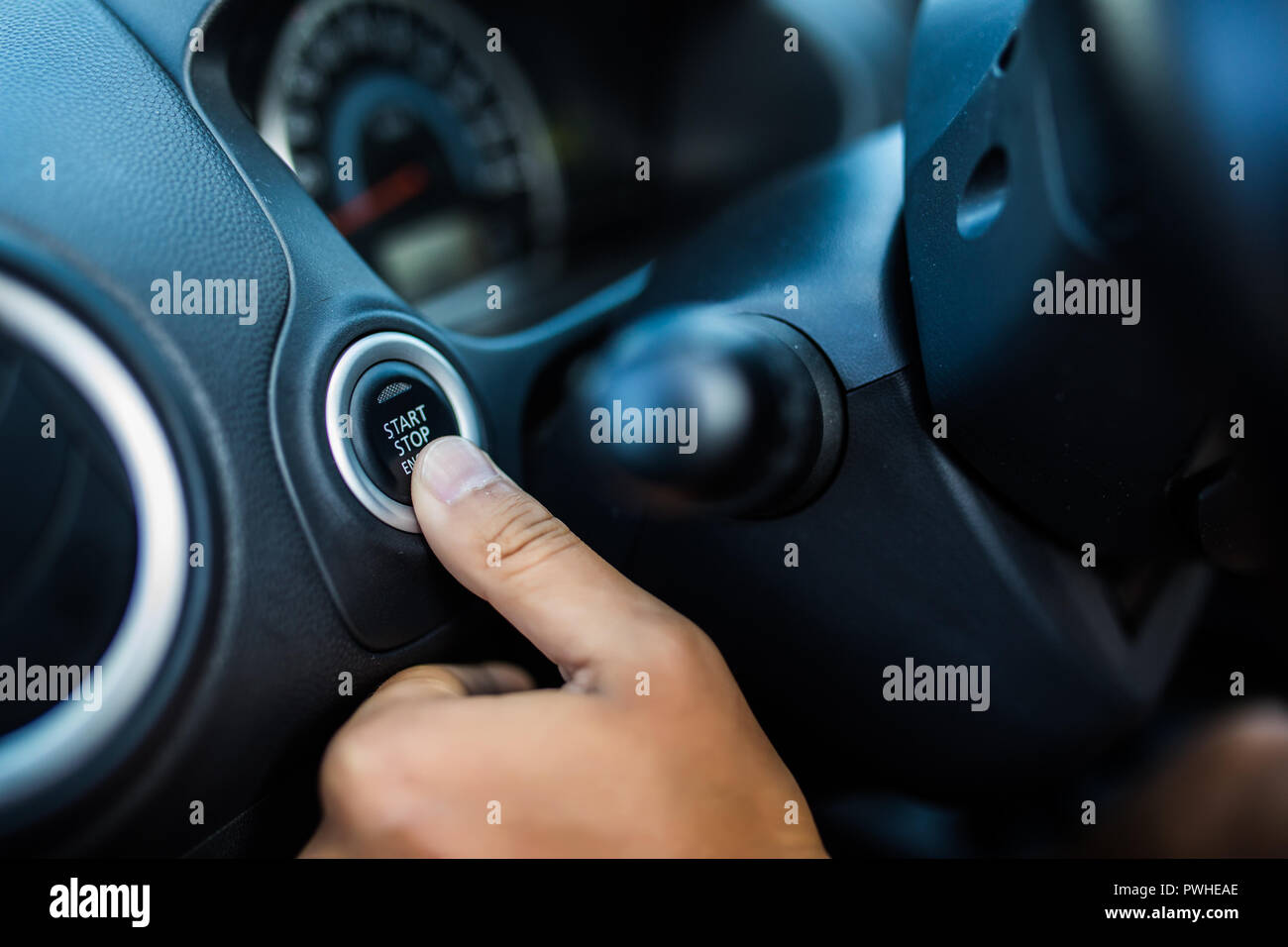 Finger of man press start button engine of car red color with silver ...