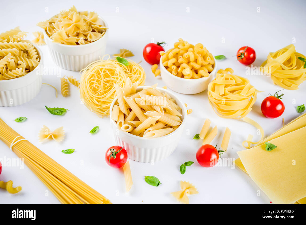 Italian food concept, various raw pasta assortment - spaghetti, lasagna ...