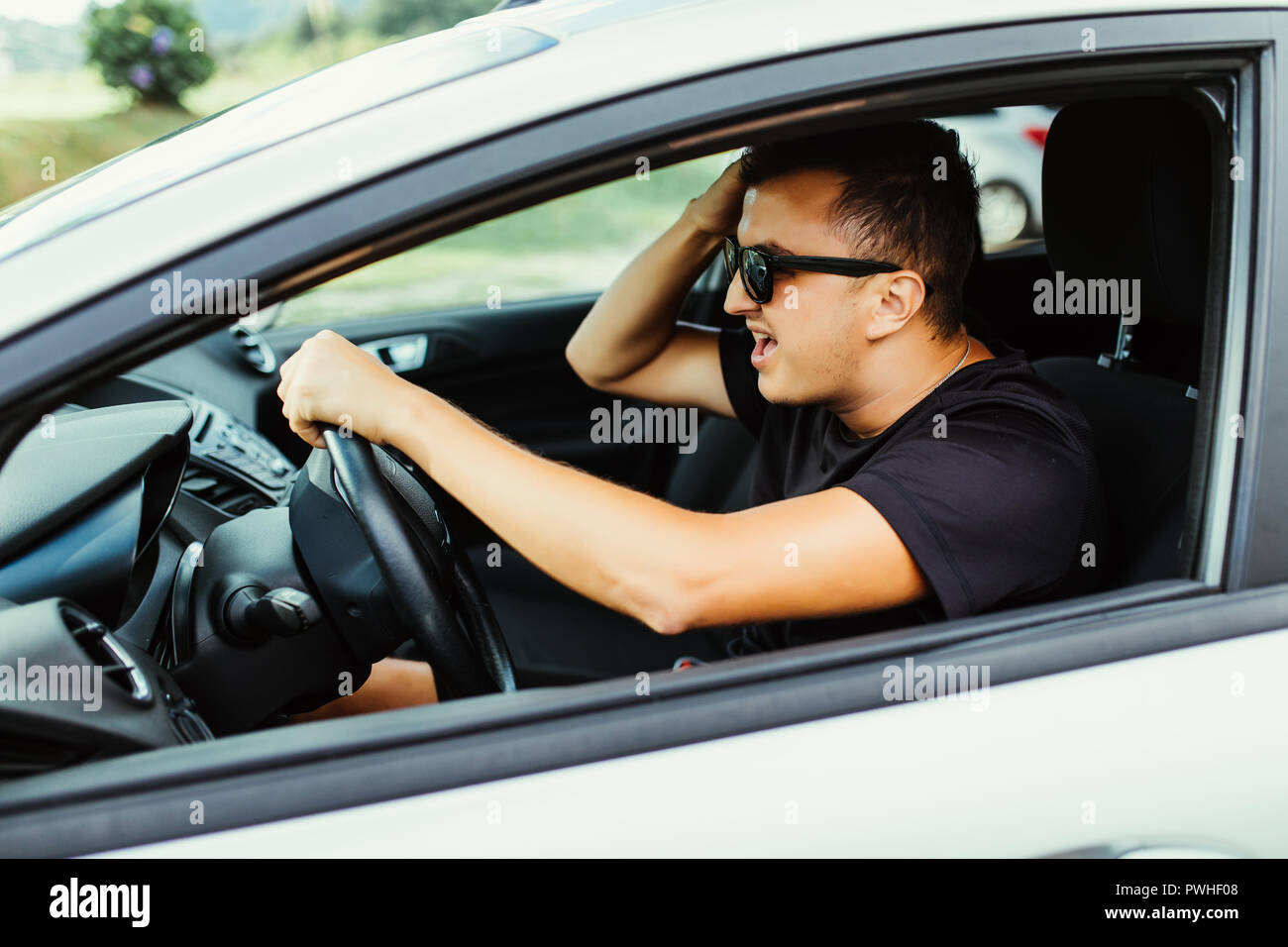 Young man driving a car shocked about to have traffic accident ...
