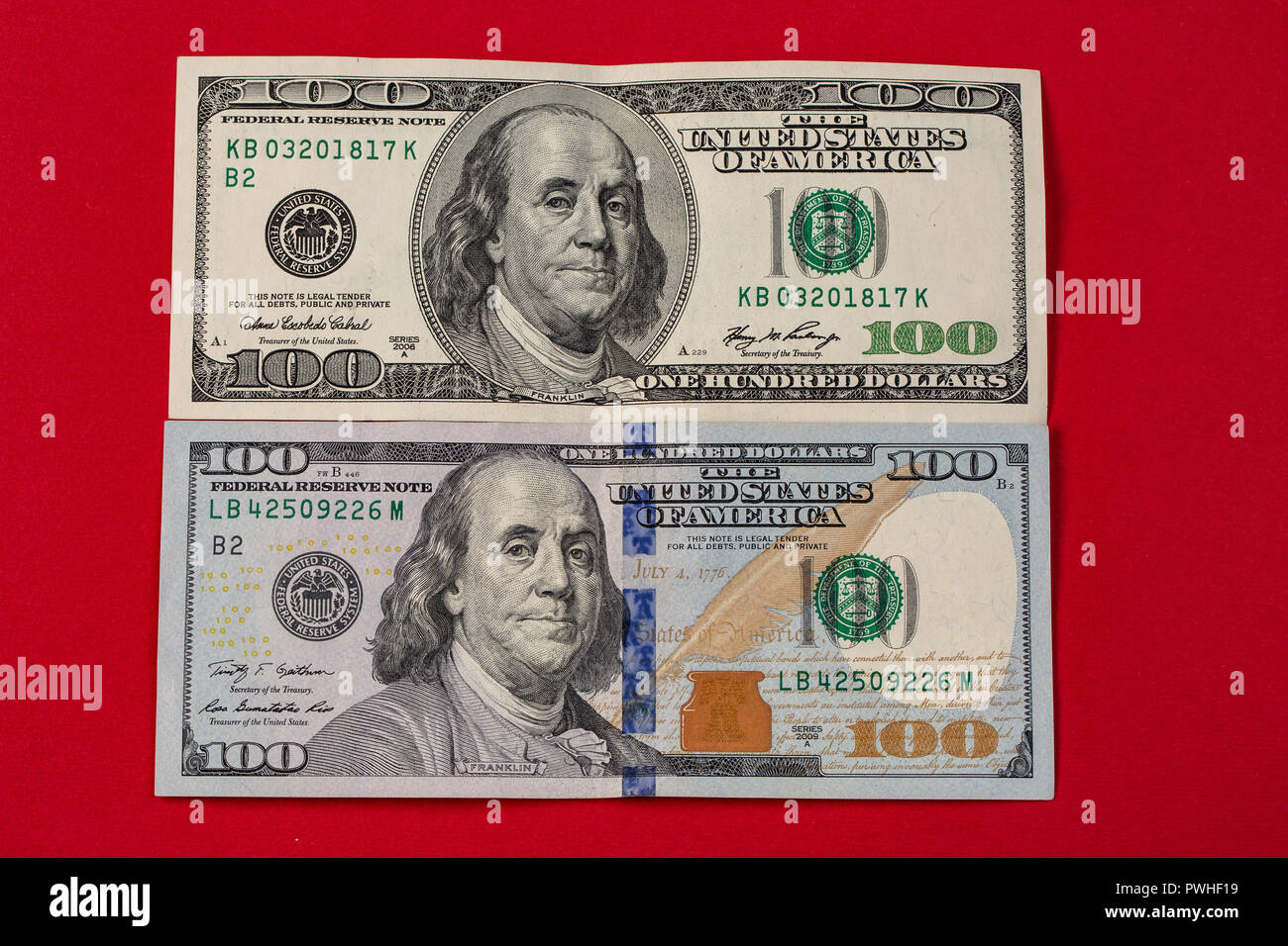 comparison of old and new hundred-dollar bill on red background at the ...