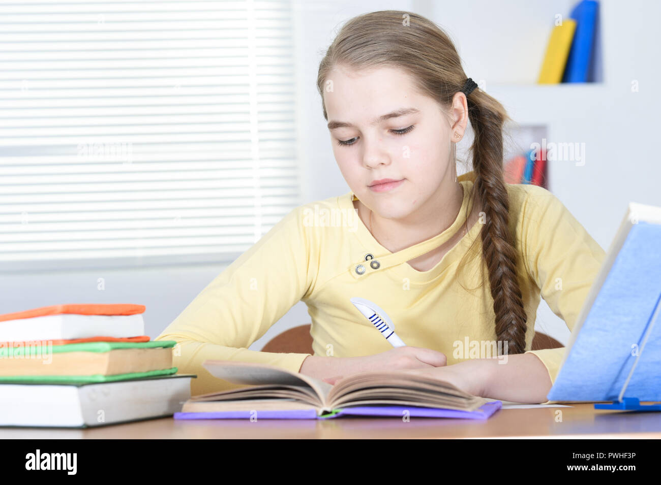 Pretty girl sitting table books hi-res stock photography and images - Alamy