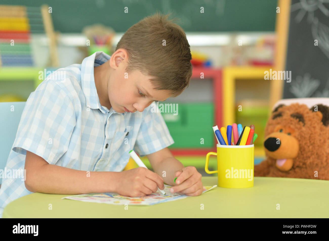 Portrait of cute little boy drawing with pencils Stock Photo - Alamy