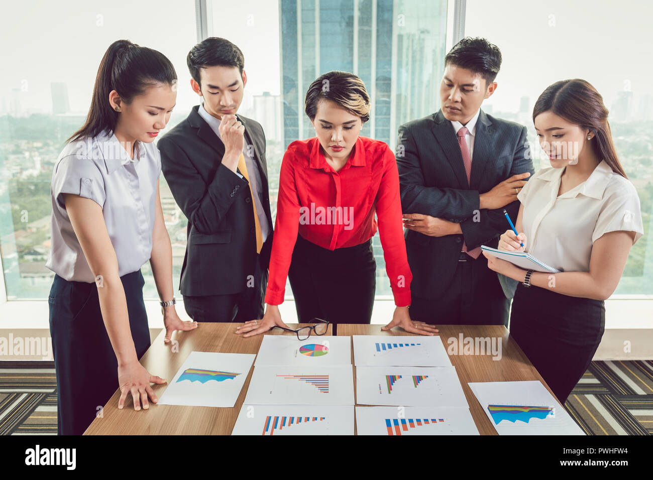 Businesspeople analyzing different business chart Stock Photo - Alamy