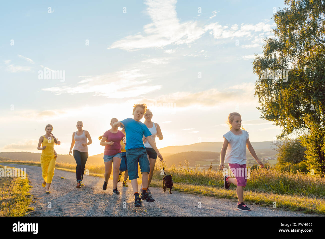 Playful family running and playing on a path in summer landscape Stock ...
