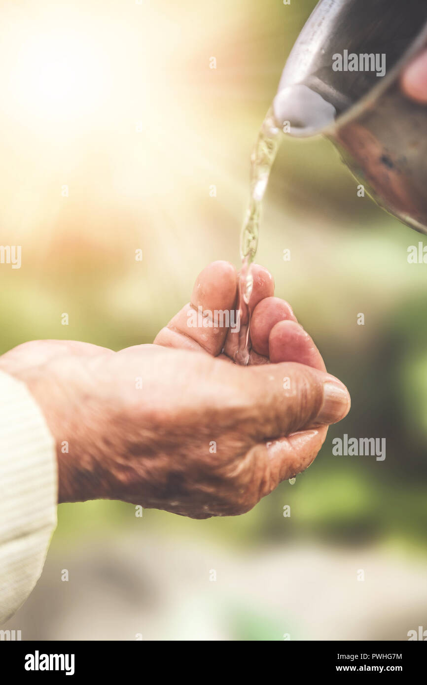 Indian old man washing hand from Lota (vessel) outdoor after having ...