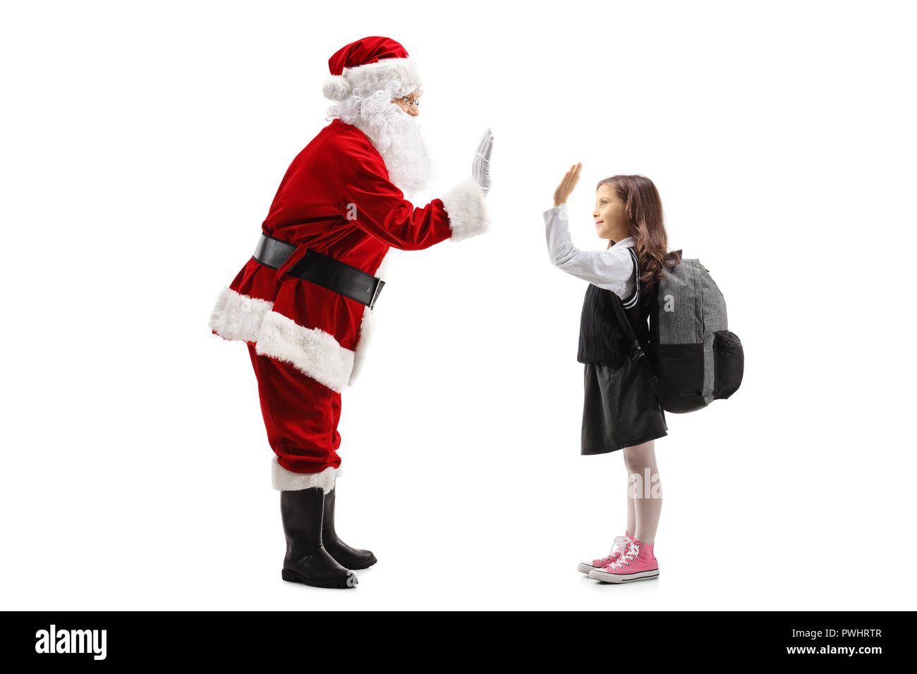 Full length profile shot of Santa Claus high-fiving a schoolgirl ...