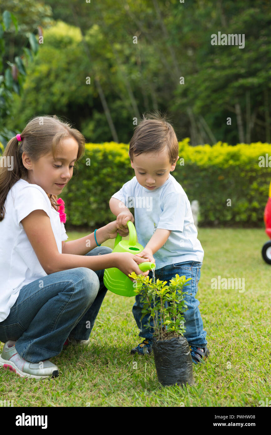 Happy Children Planting Garden In The Park Stock Photo - Alamy