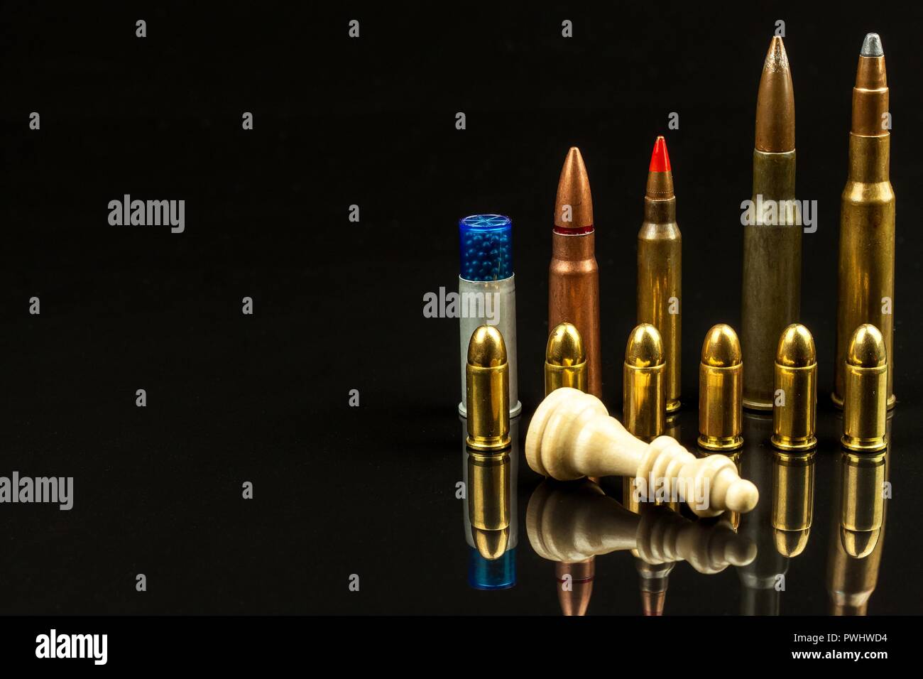 Chess pieces and ammunition on a black background. Play chess ...