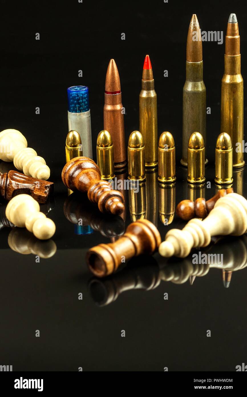Chess pieces and ammunition on a black background. Play chess ...