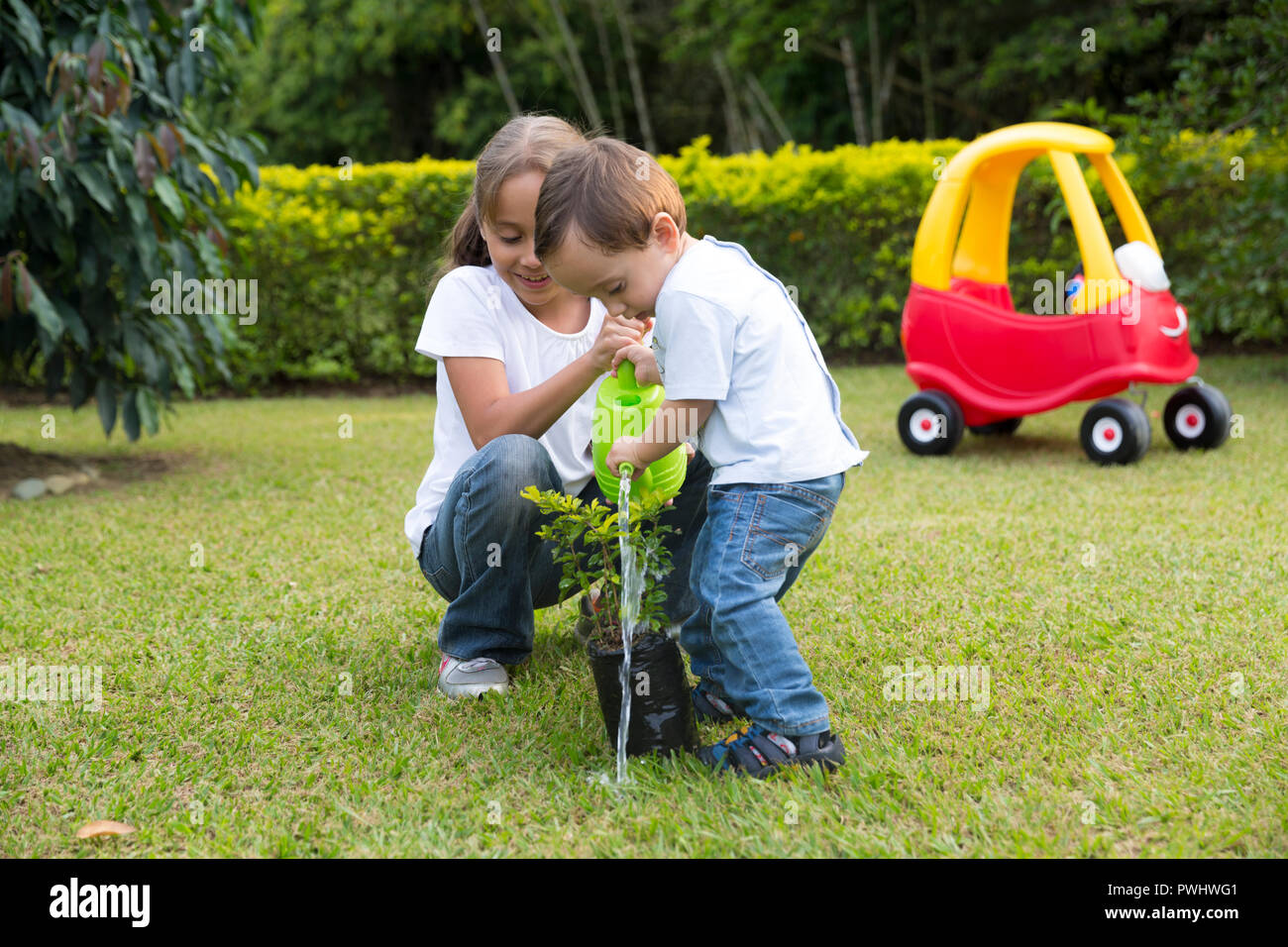 Happy Children Planting Garden In The Park Stock Photo - Alamy