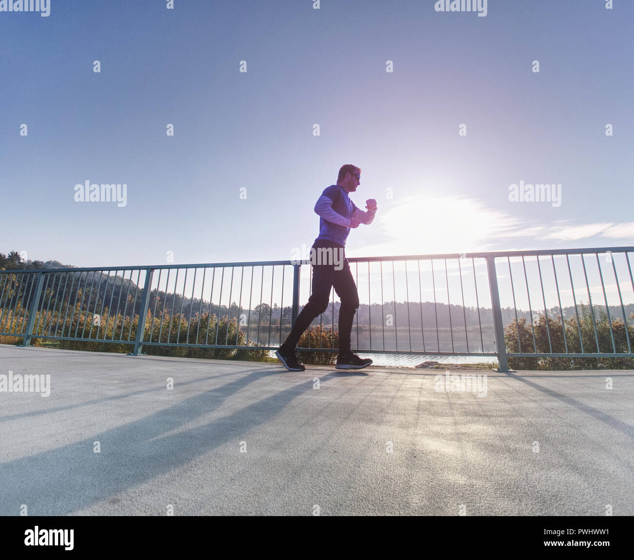 Sporty man run up the bridge . Sport and lifestyle concept - slim man ...