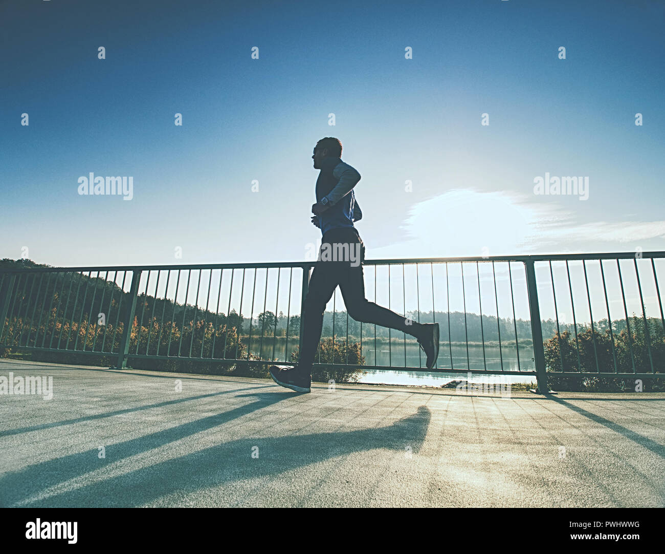 Sporty man run up the bridge . Sport and lifestyle concept - slim man ...