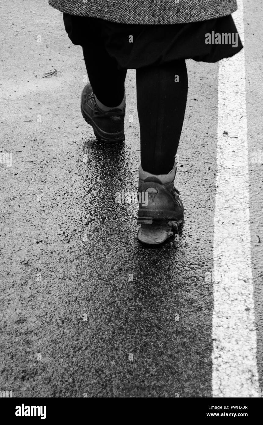 A girl with a broken boot sole keeps walking Stock Photo - Alamy