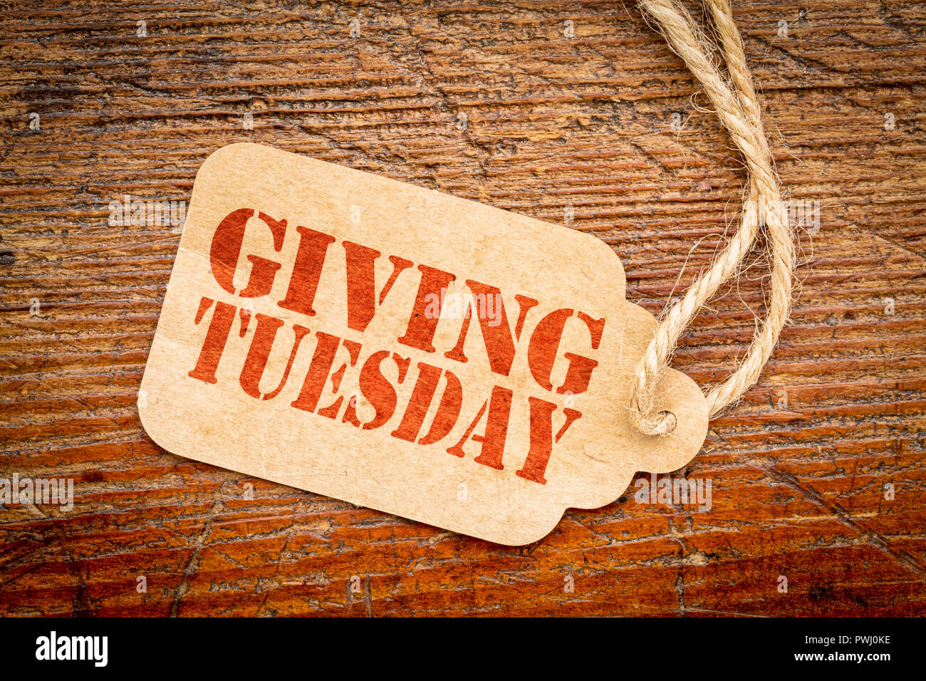Giving Tuesday sign - a paper price tag with a twine on a rustic wood ...