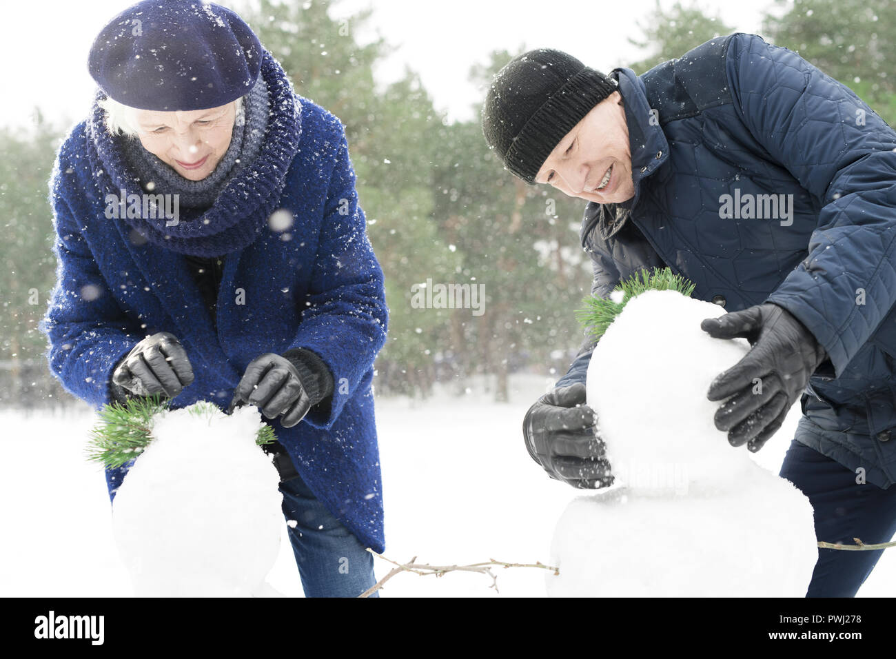 Senior Couple Building Snowman Stock Photo - Alamy