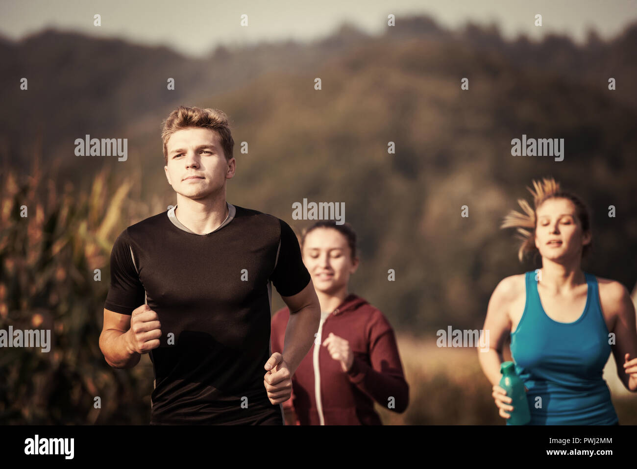 group of young people jogging on country road runners running on open ...