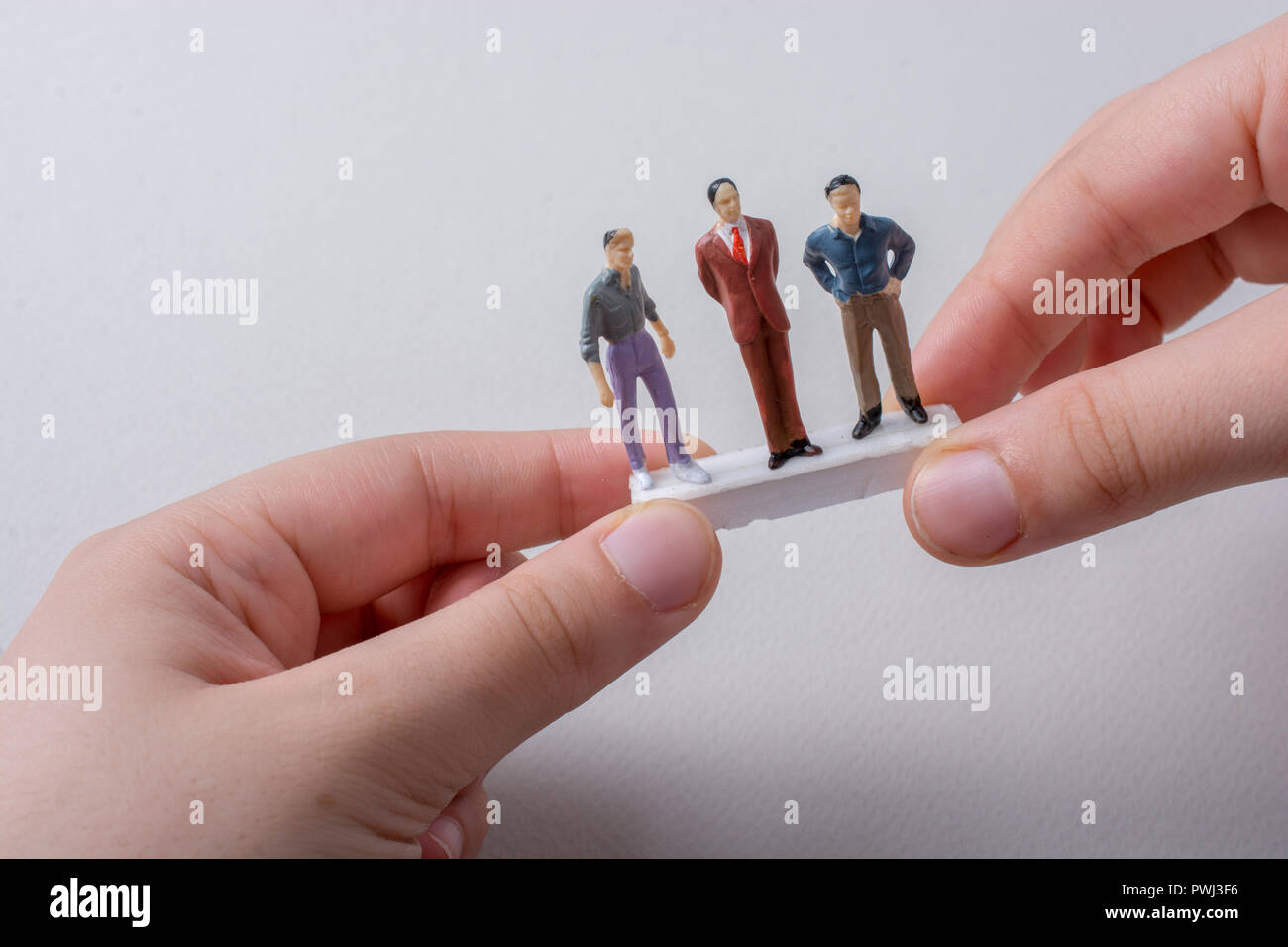 Tiny figurines of men miniature model in hand Stock Photo - Alamy