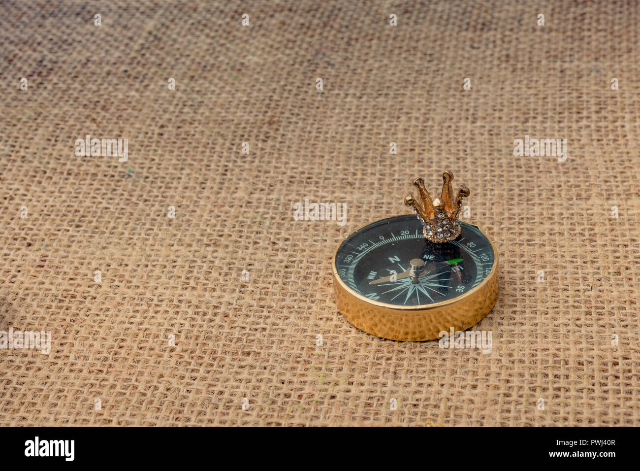 Compass and mini crown placed on a canvas background Stock Photo - Alamy