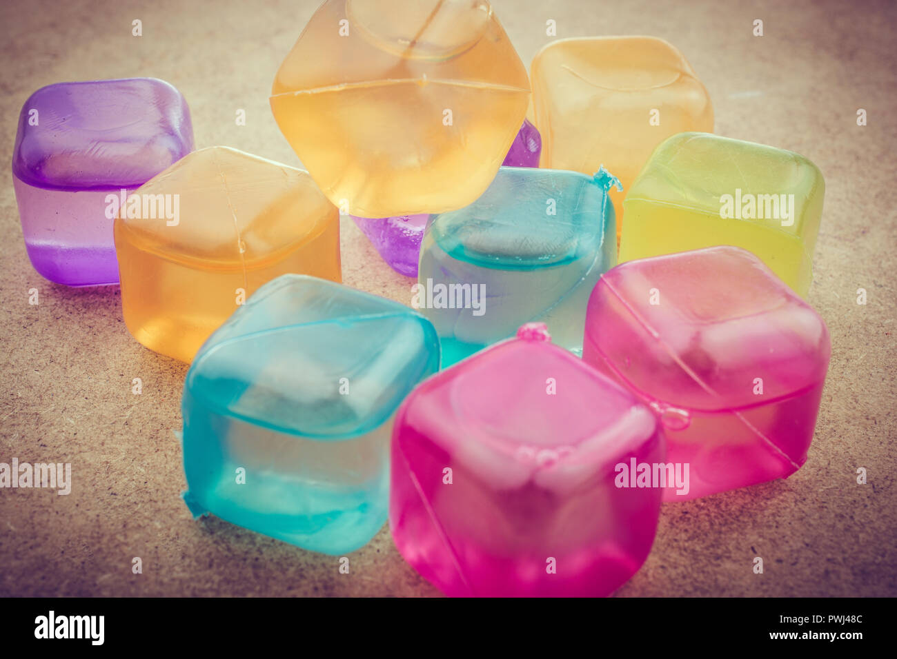 Fake colorful ice cubes on a brown background Stock Photo - Alamy