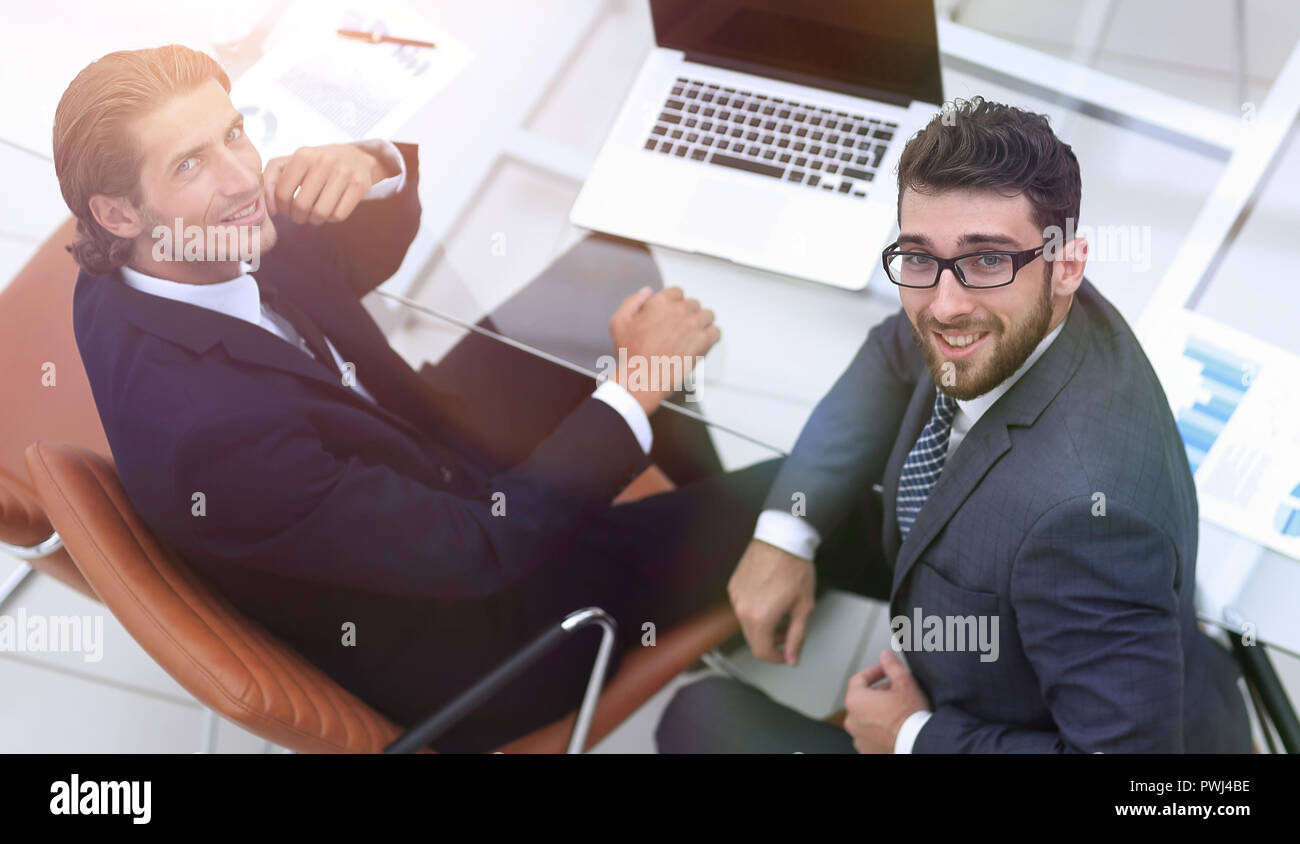 successful employees sitting behind a Desk Stock Photo - Alamy