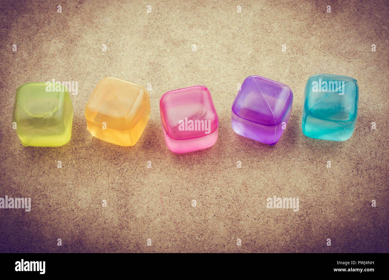 Fake colorful ice cubes on a brown background Stock Photo - Alamy