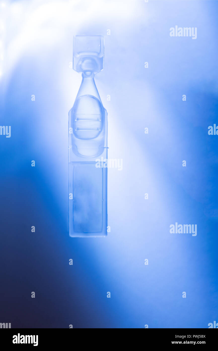 Artificial tears and eye drop capsule isolated on blue background with ...