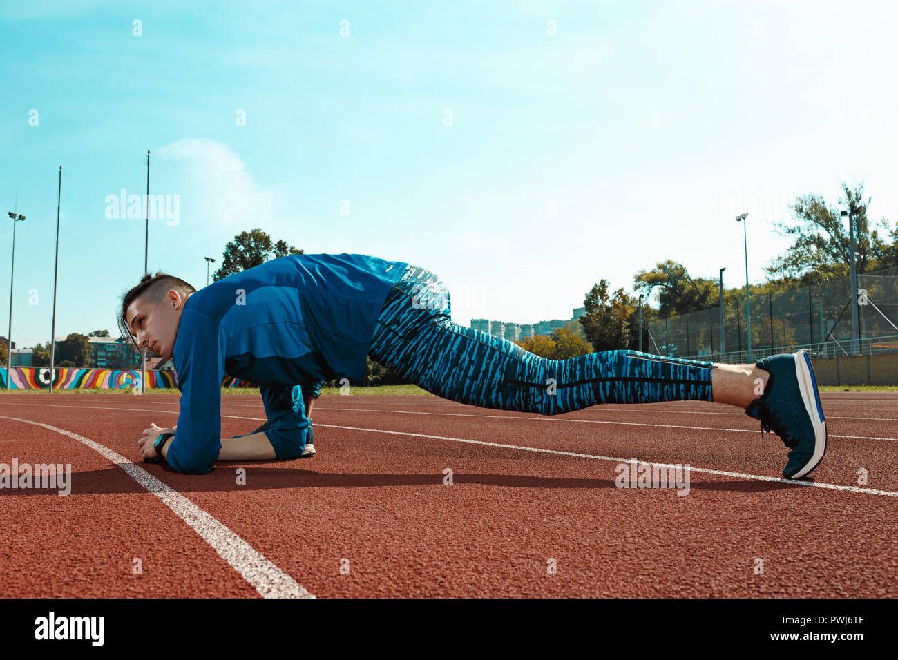 The fit male runner stretching legs preparing for run during training ...