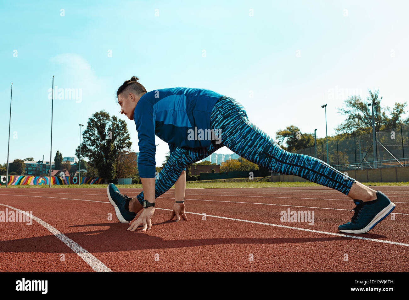 The fit male runner stretching legs preparing for run during training ...