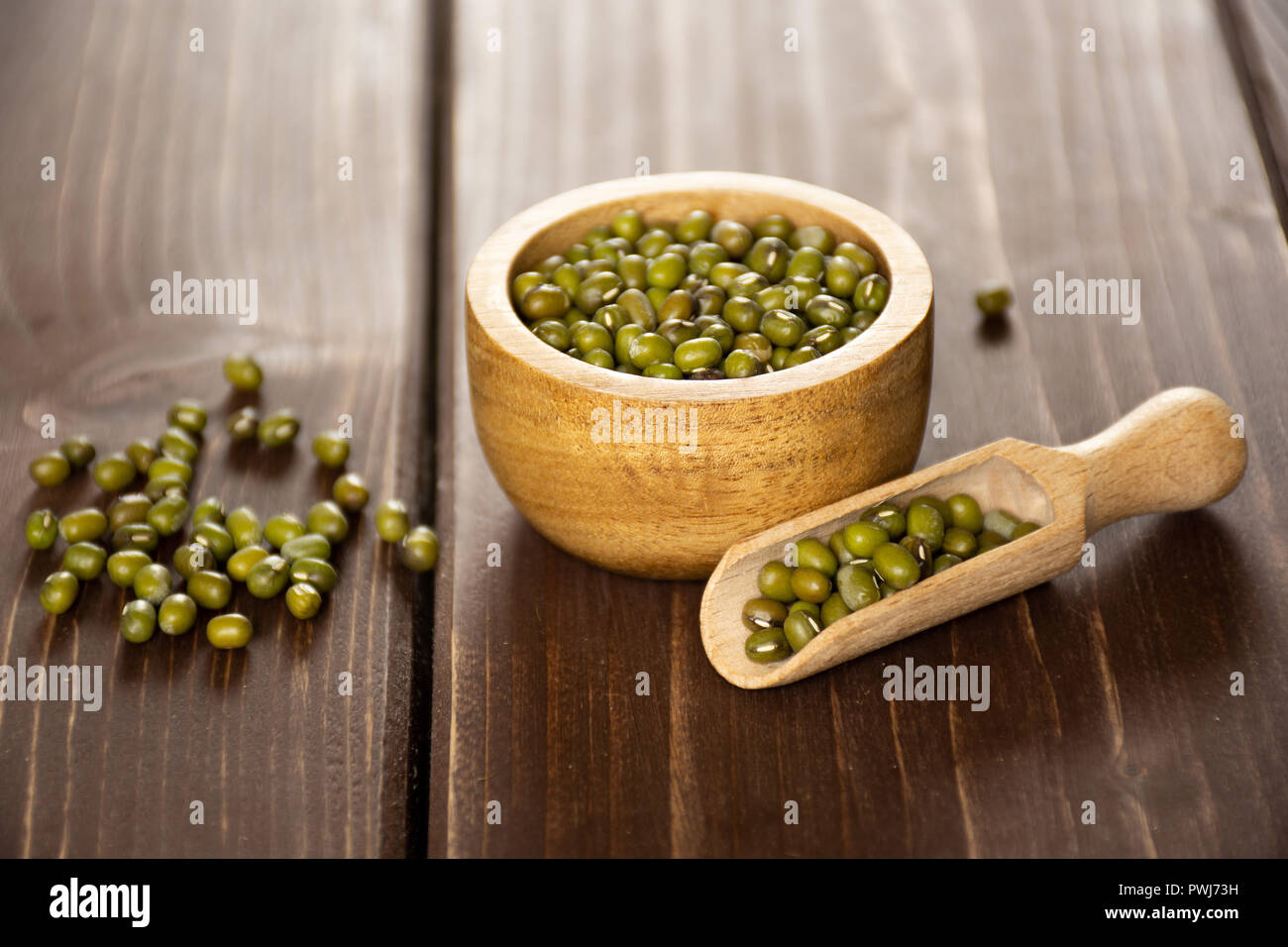 Set of lot of whole dry green mung beans with wooden bowl on brown wood ...