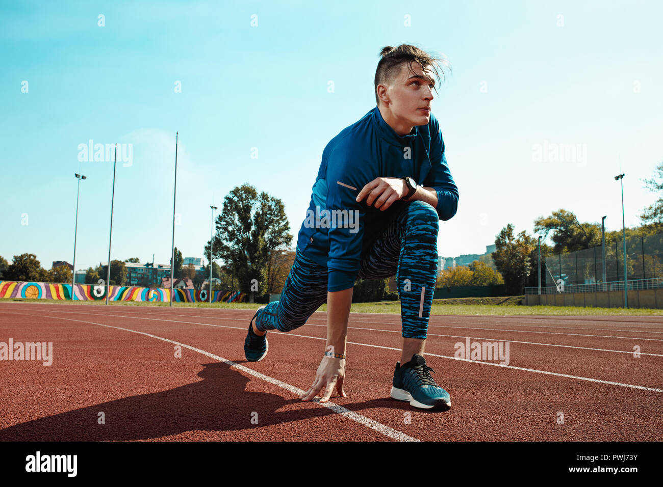 The fit male runner stretching legs preparing for run during training ...