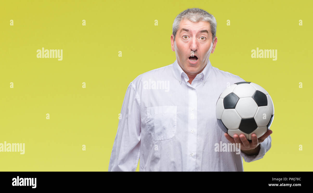 Handsome senior man holding soccer football ball over isolated ...