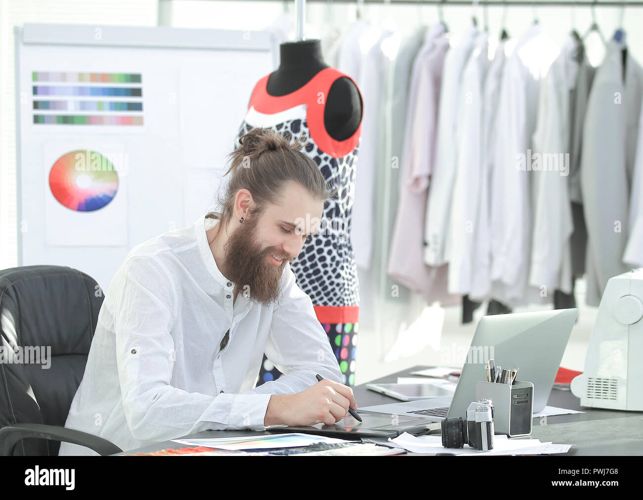 fashion designer uses a graphics tablet to create sketches of clothes ...
